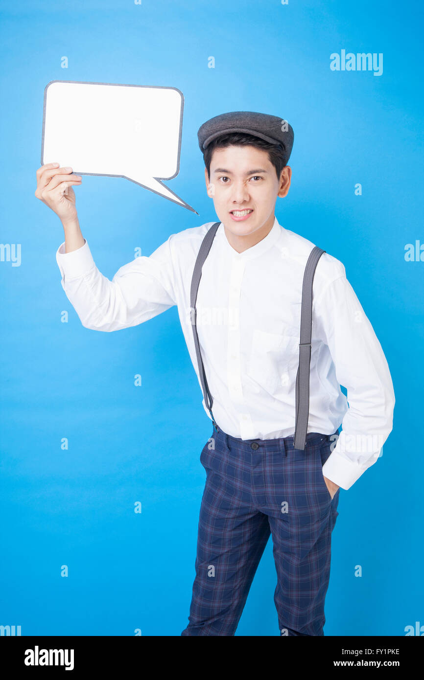 Young man in retro style posing holding a speech balloon with a frown ...