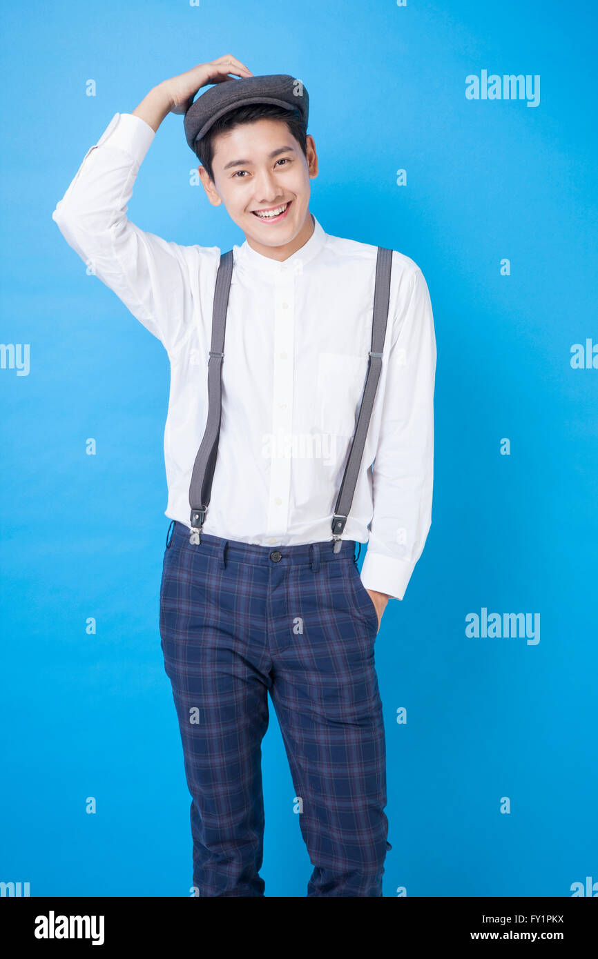 Young smiling man in retro style posing touching his cap staring at ...