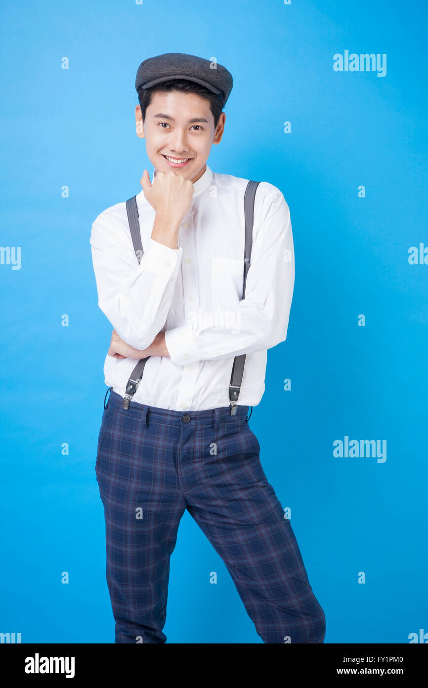 Young smiling man in retro style posing with his chin on his hand ...
