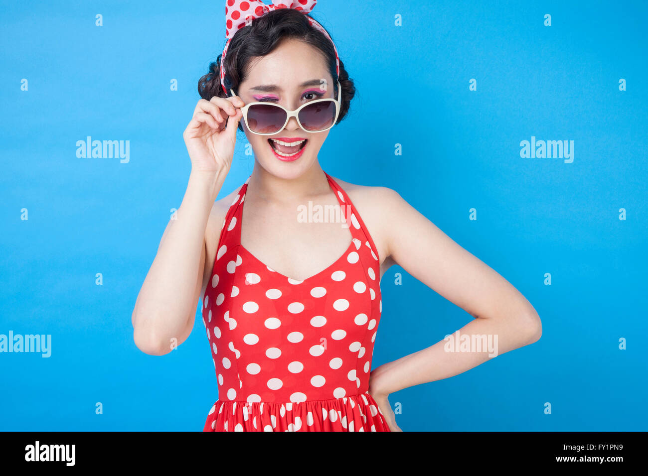 Portrait of young smiling woman in retro style winking staring at front ...