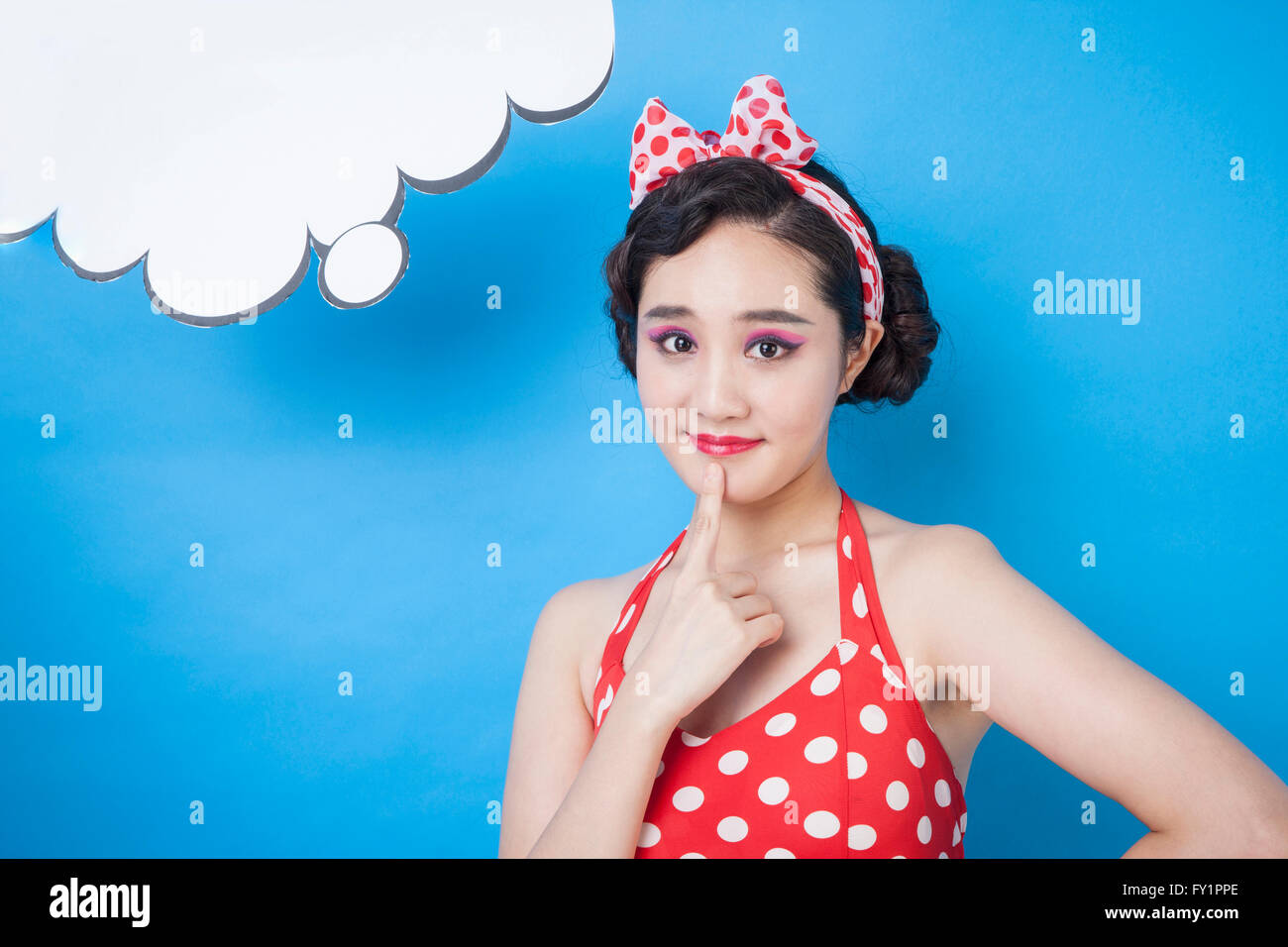 Portrait of young woman in retro style touching her lips with thought ...