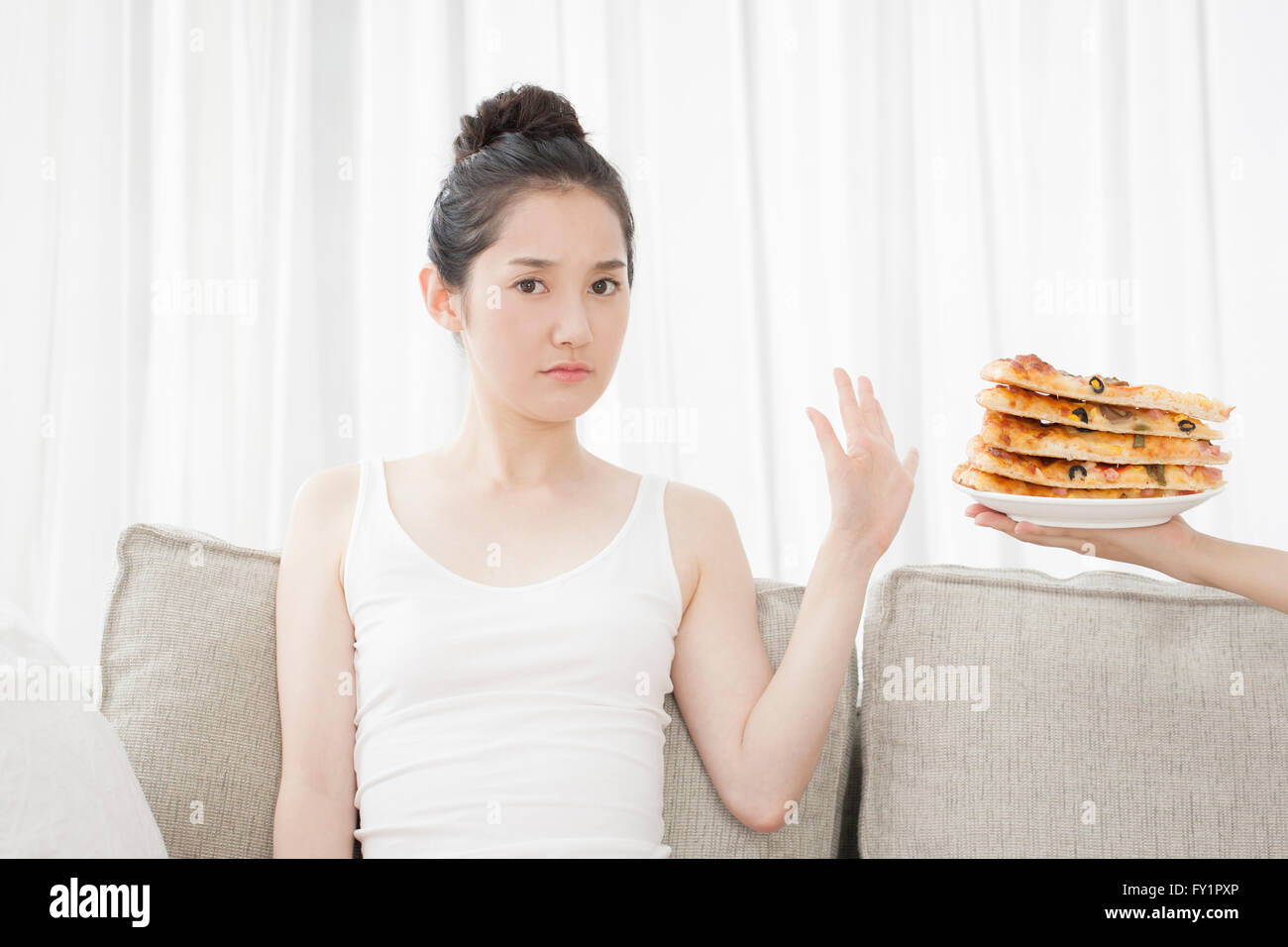 Portrait of young woman rejecting pizza Stock Photo - Alamy