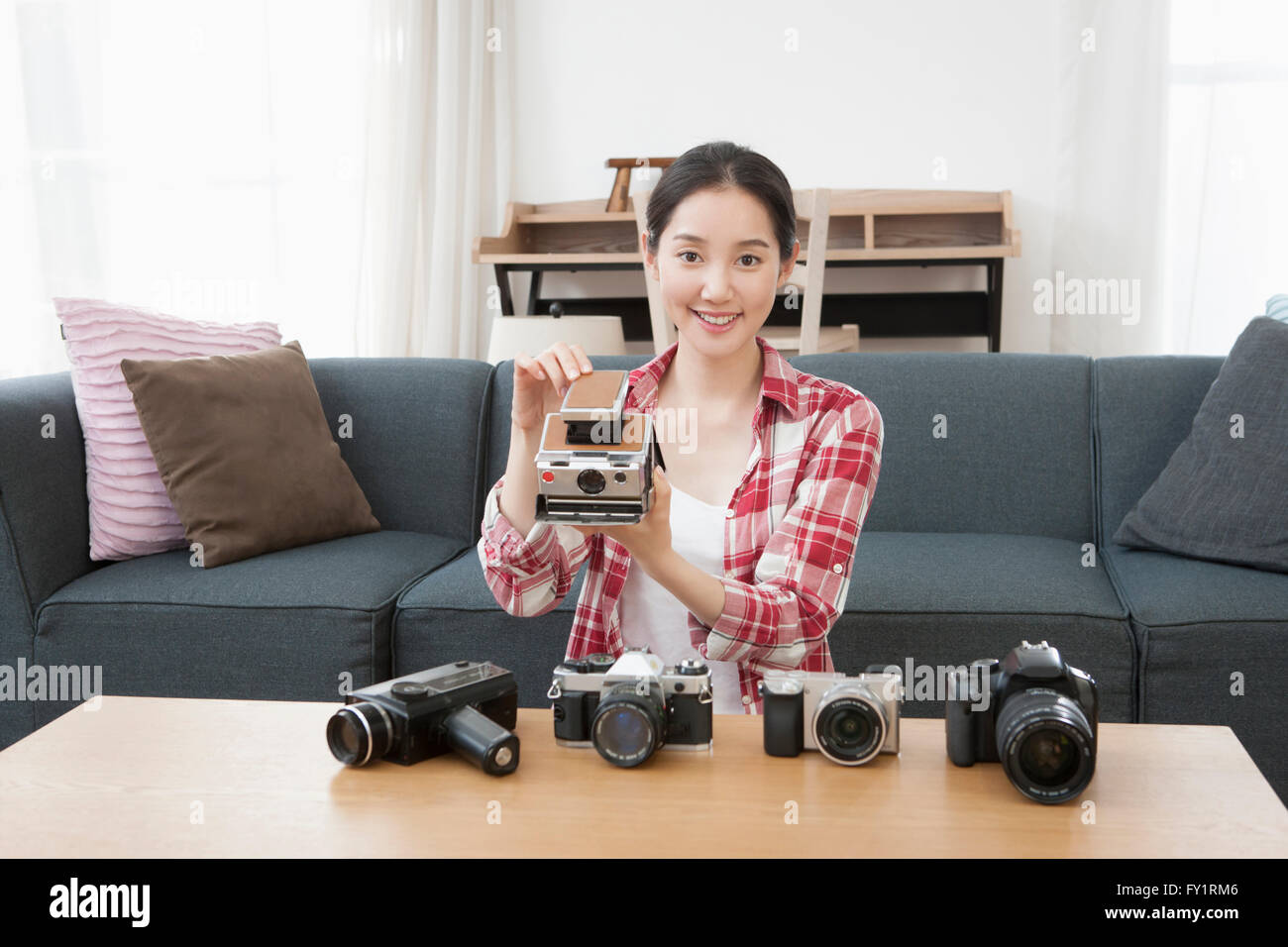 Portrait of young smiling woman with various cameras Stock Photo - Alamy