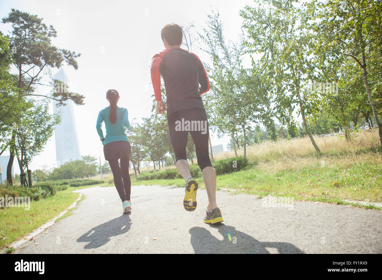Back of young couple running at park Stock Photo - Alamy