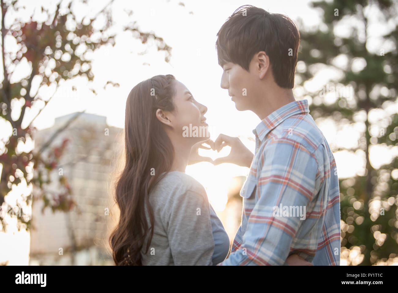 Side view of young couple face ro face Stock Photo - Alamy