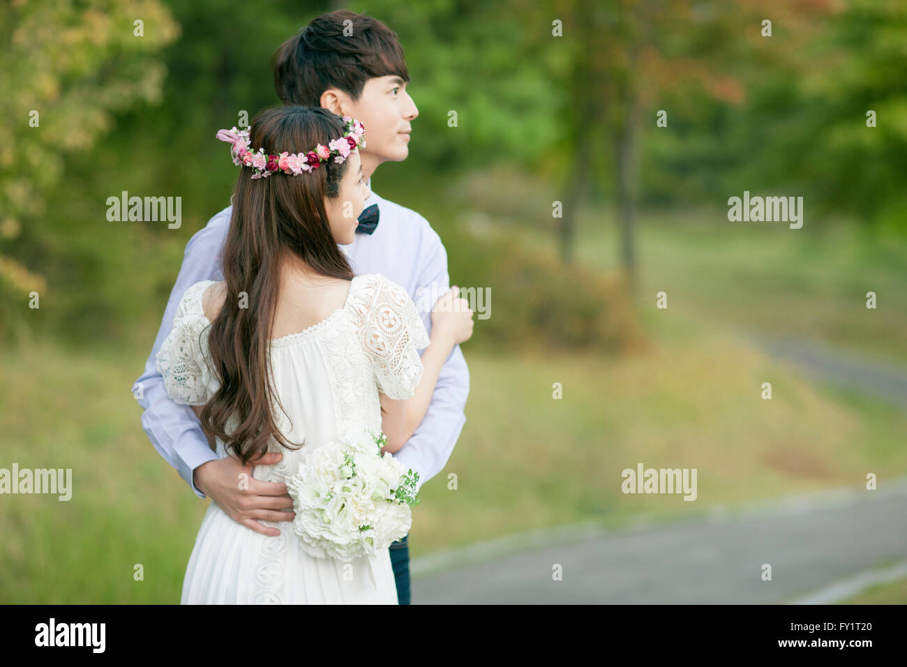 Side view portrait of young wedding couple at park Stock Photo - Alamy