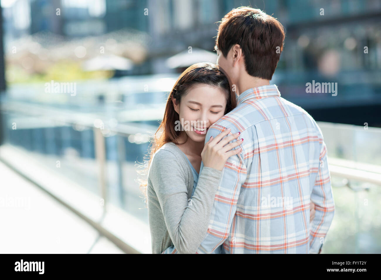 Side view portrait of young couple hugging closing eyes Stock Photo - Alamy