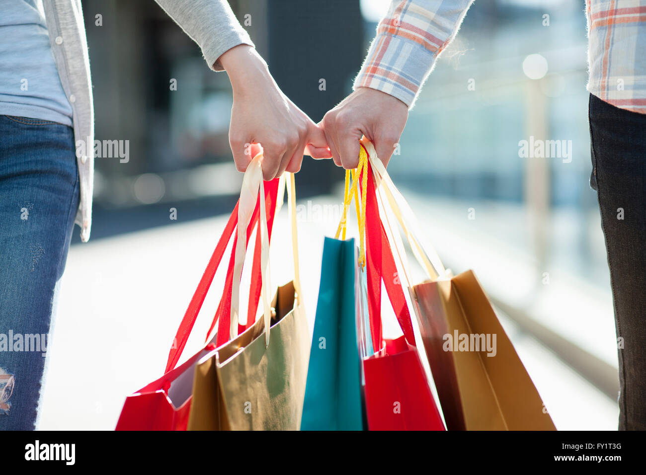 Hands holding lots of shopping bags Stock Photo - Alamy