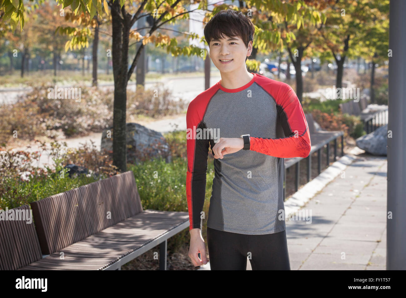 Young smiling man wearing smart watch Stock Photo - Alamy