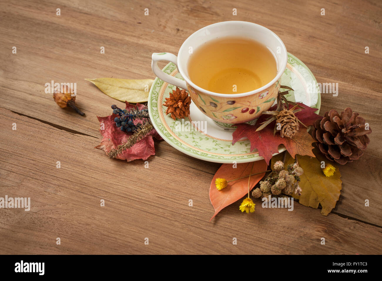 Background of autumn with a cup of tea, fallen leaves, dry flowers and ...