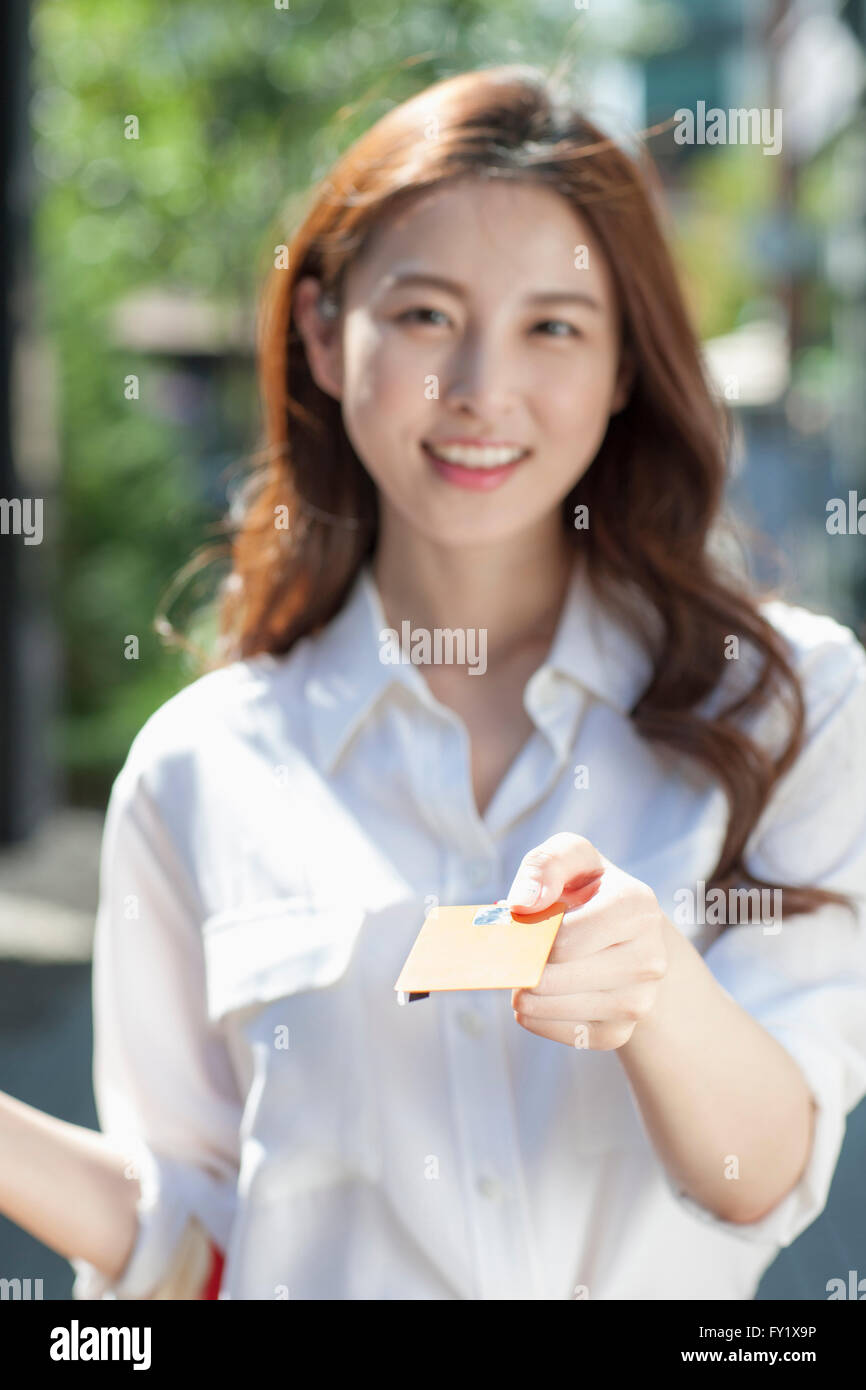 Woman giving a credit card forward with shopping bags Stock Photo - Alamy