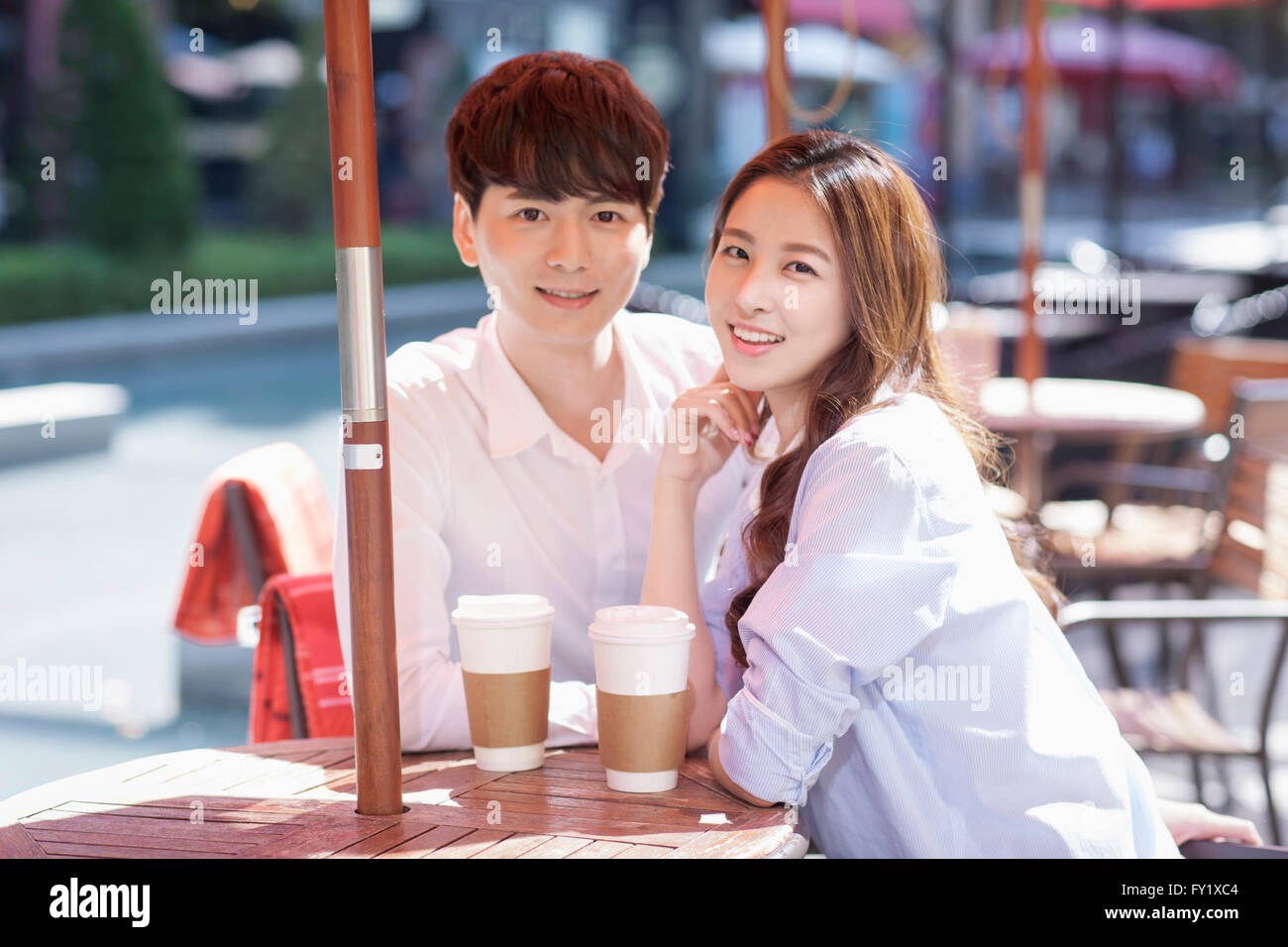 Couple having a coffee break at the terrace of a cafe Stock Photo - Alamy