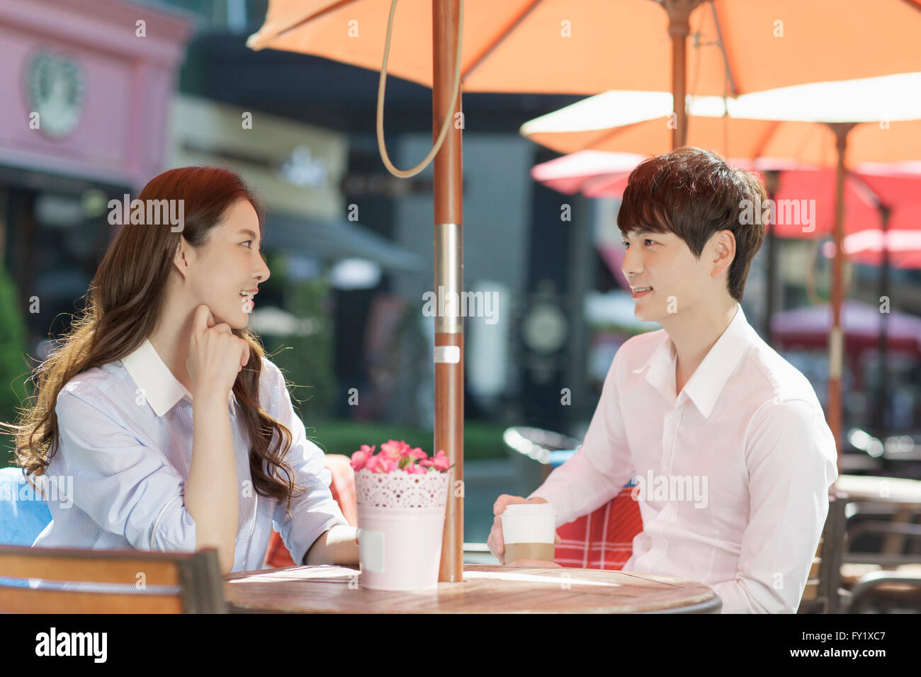 Couple having a coffee break at the terrace of a cafe Stock Photo - Alamy
