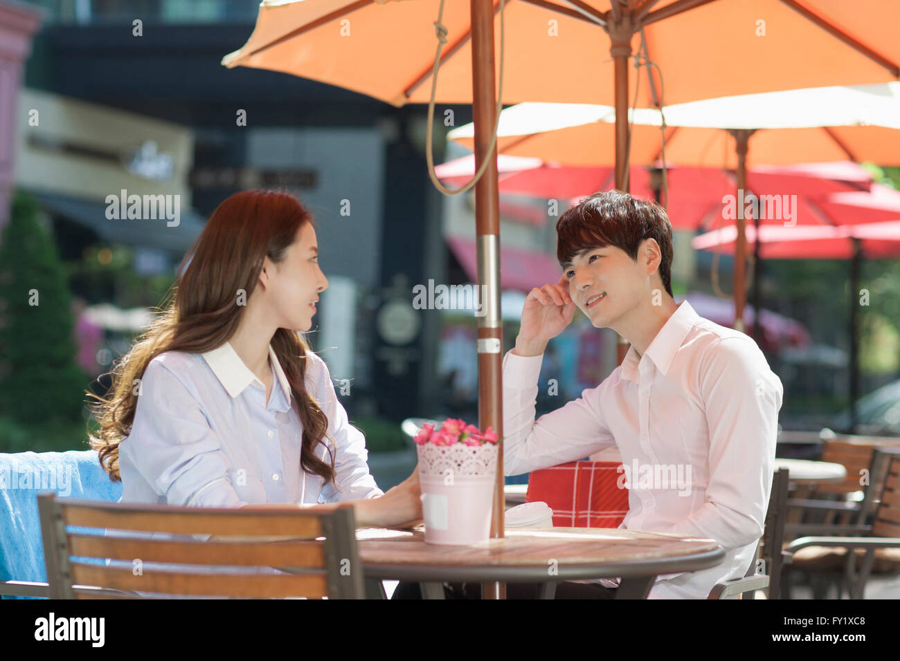 Couple having a coffee break at the terrace of a cafe Stock Photo - Alamy