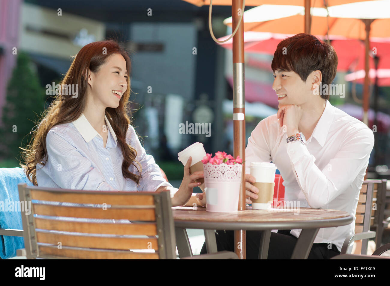 Couple having a coffee break at the terrace of a cafe Stock Photo - Alamy