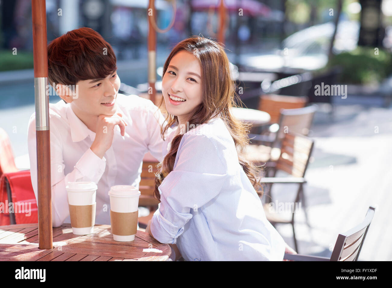 Couple having coffee break at the outdoor cafe with coffee on the table ...