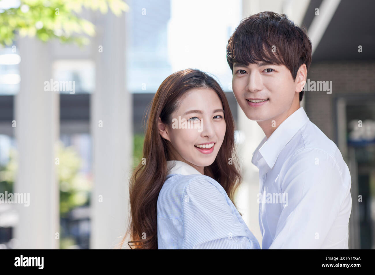 Couple staring forward with a smile outside Stock Photo - Alamy