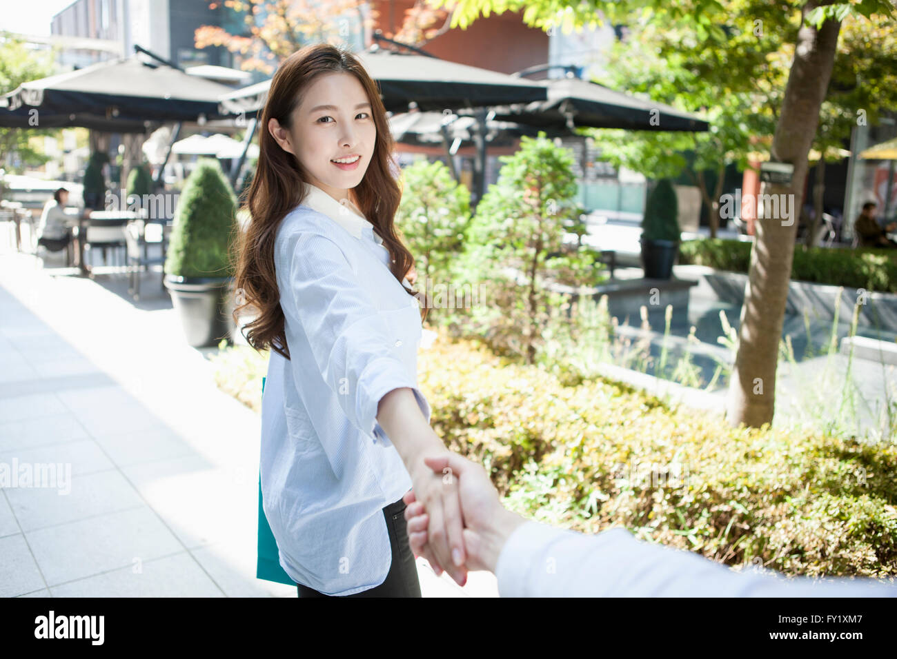 Woman pulling a hand of man outside Stock Photo - Alamy
