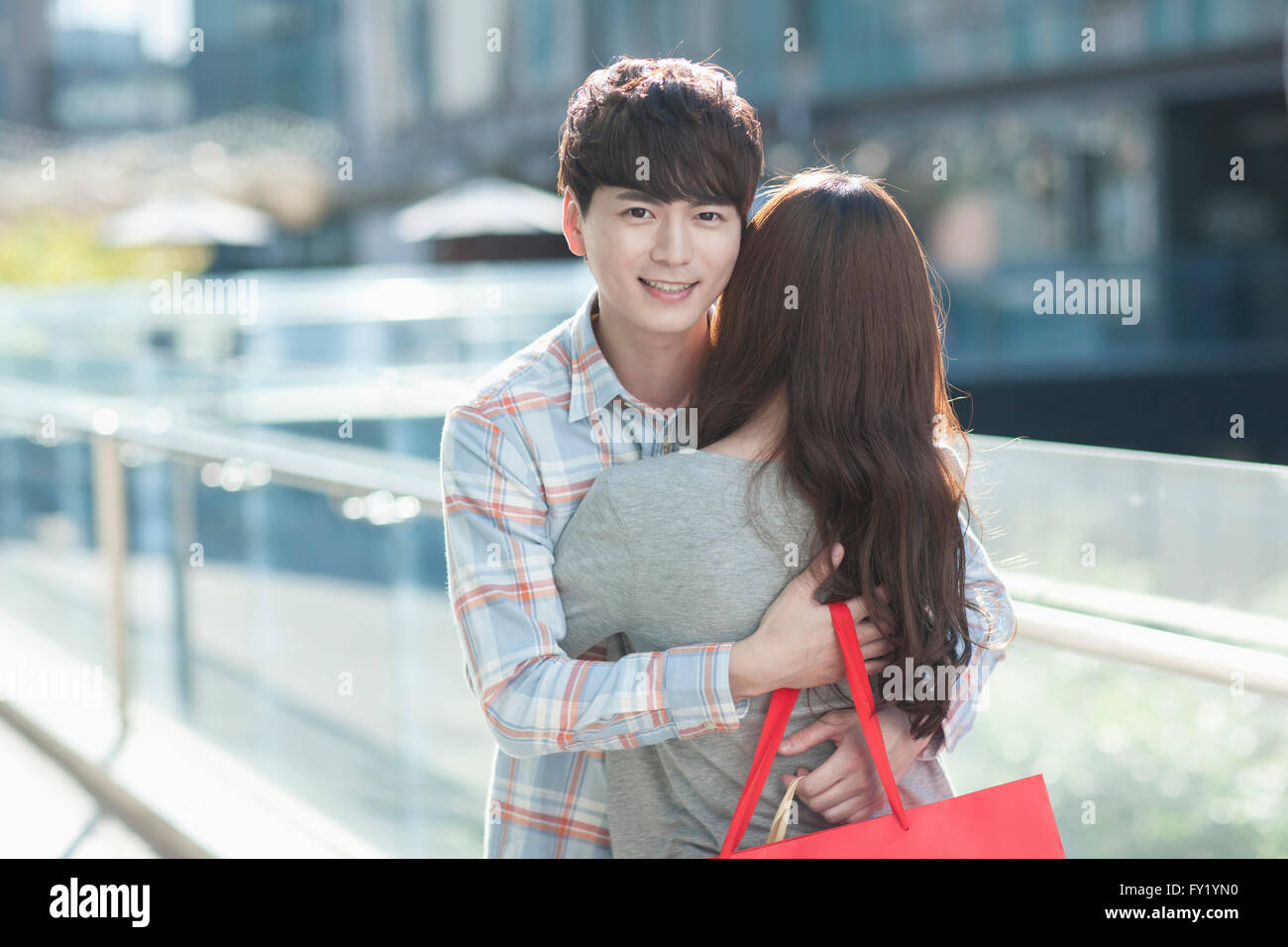 Couple hugging each other and man staring forward with a smile with a ...