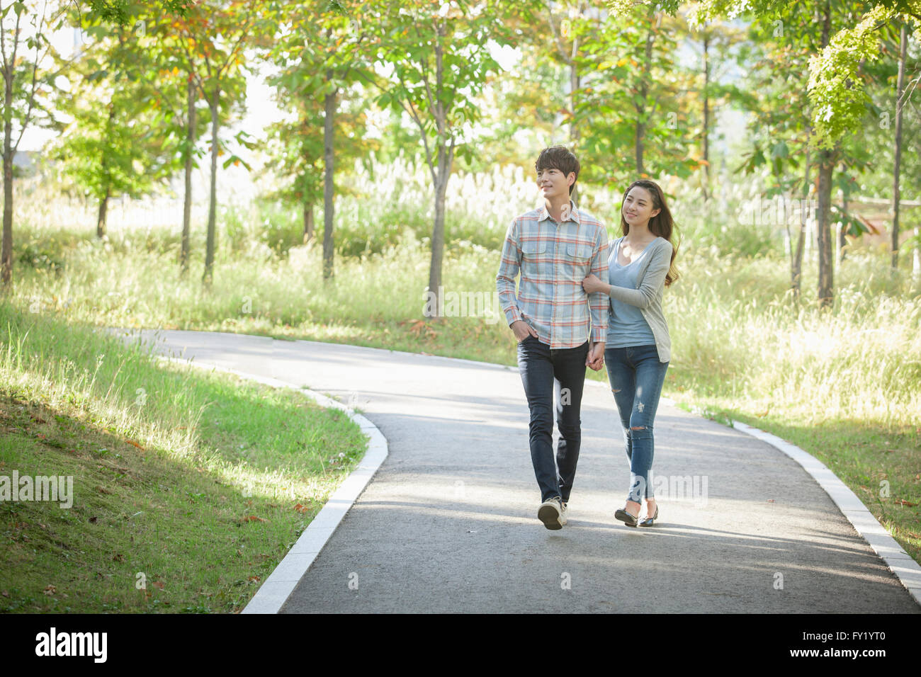 Couple walking hand in hand at the park Stock Photo - Alamy
