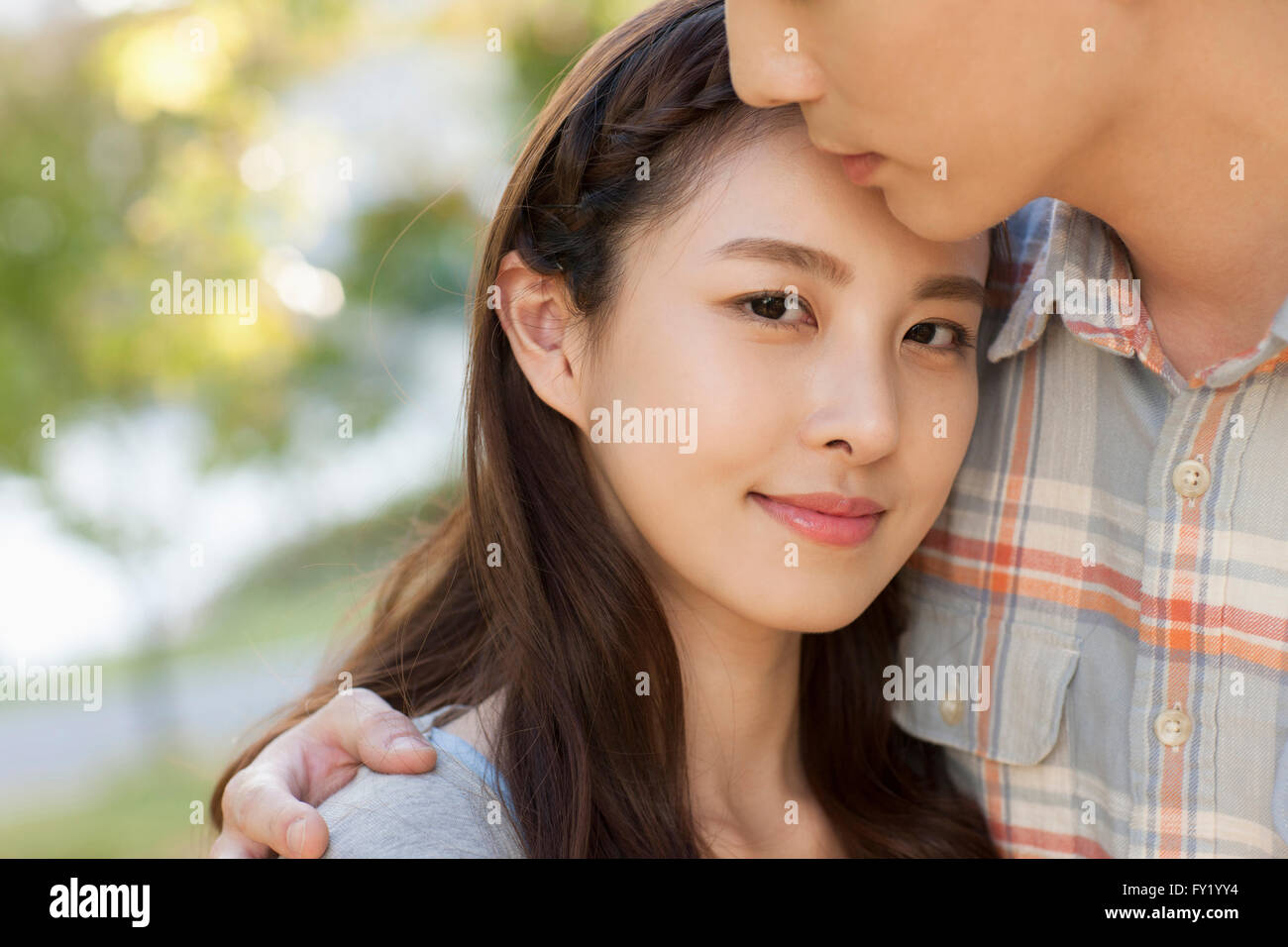 Woman with her boyfriend staring forward with a smile Stock Photo - Alamy