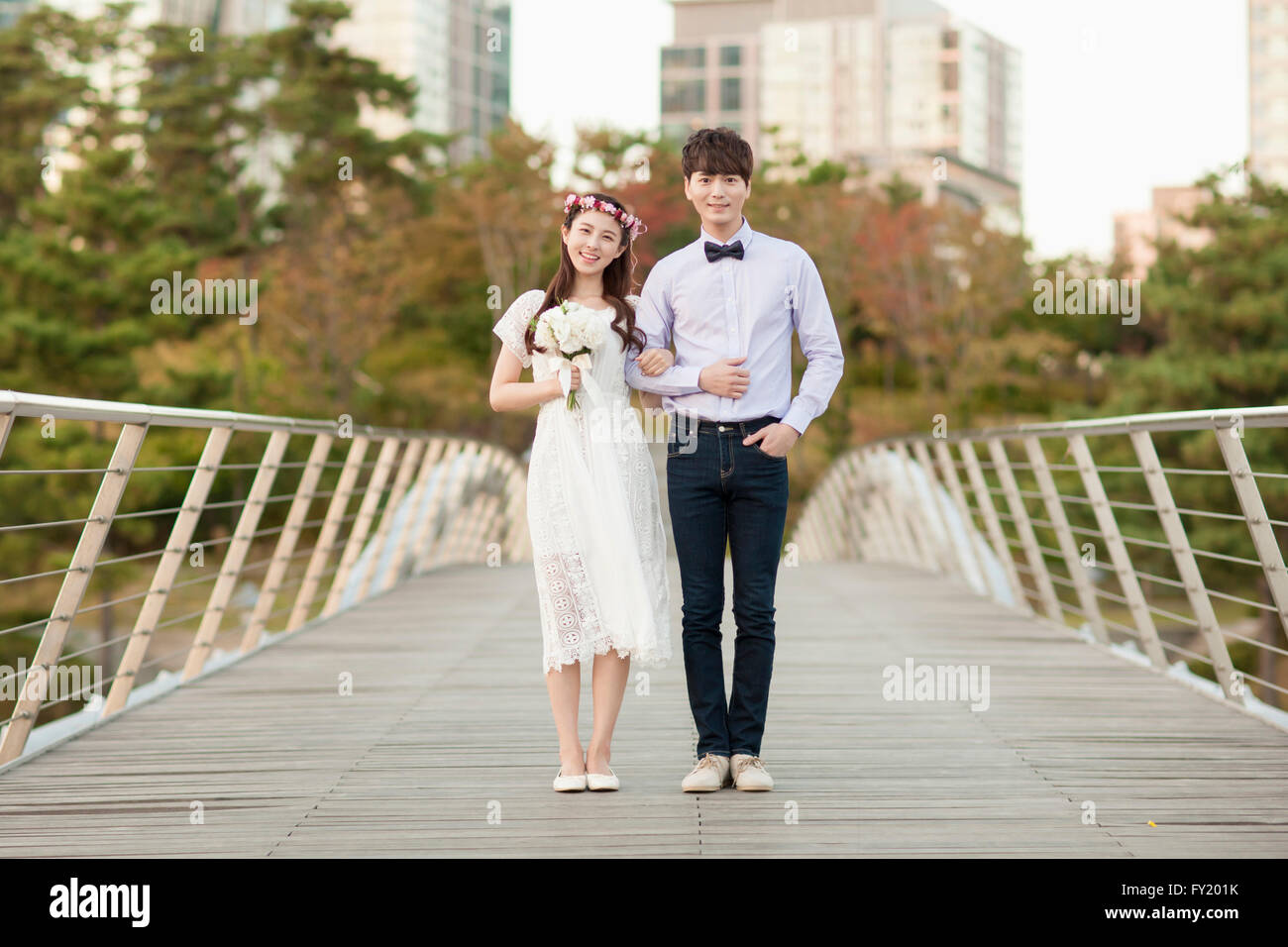 Bride and groom standing on a bridge together Stock Photo - Alamy