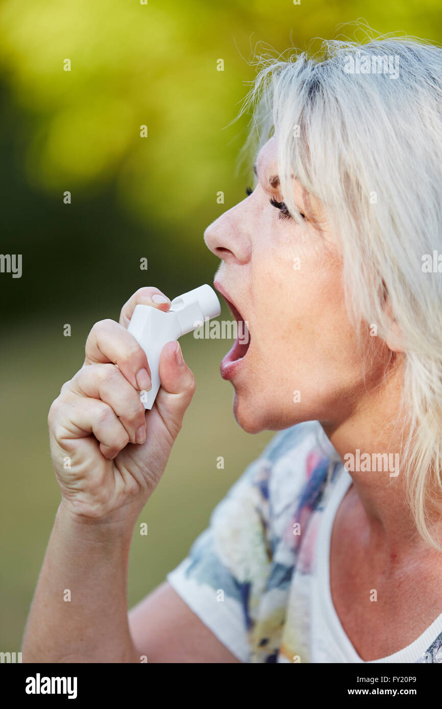 Senior woman using spray as a medicine against Asthma Stock Photo - Alamy