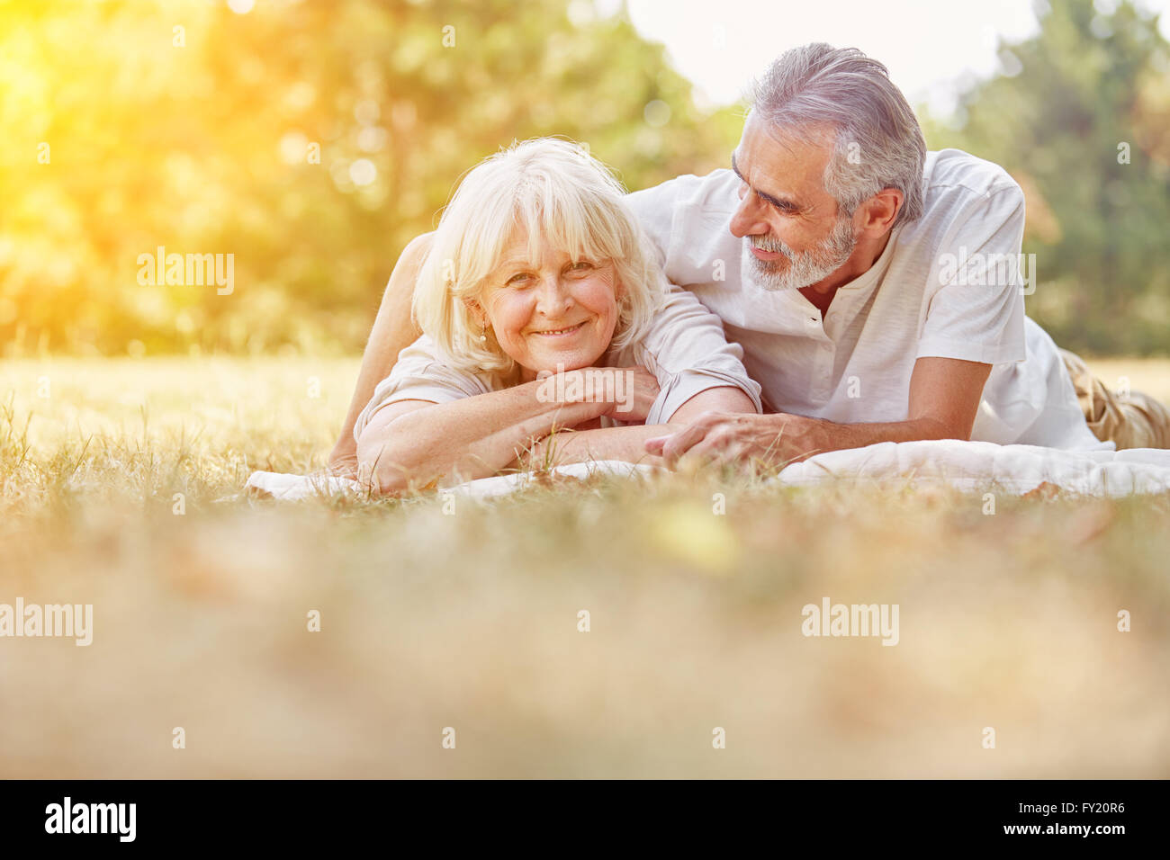 Two senior citizens relaxing in summer in the garden on a blanket Stock ...