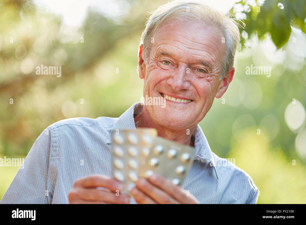 Senior man with medicament in his hands laughing in summer Stock Photo ...