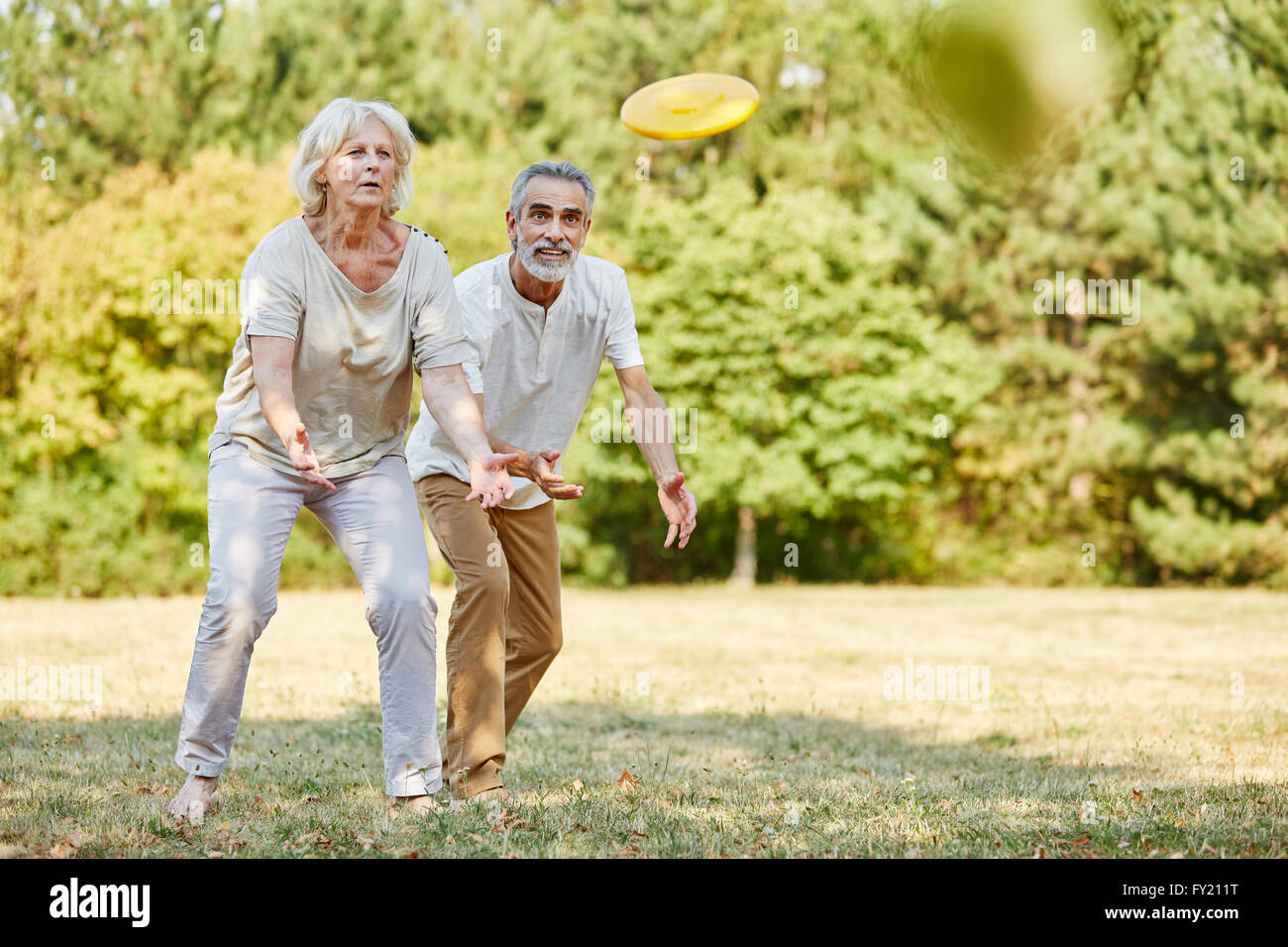 Active senior couple playing frisbee with vitality in summer Stock ...