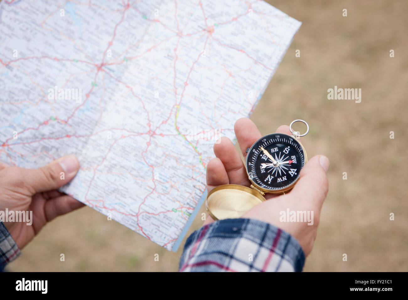 Hands holding a compass and a map Stock Photo - Alamy