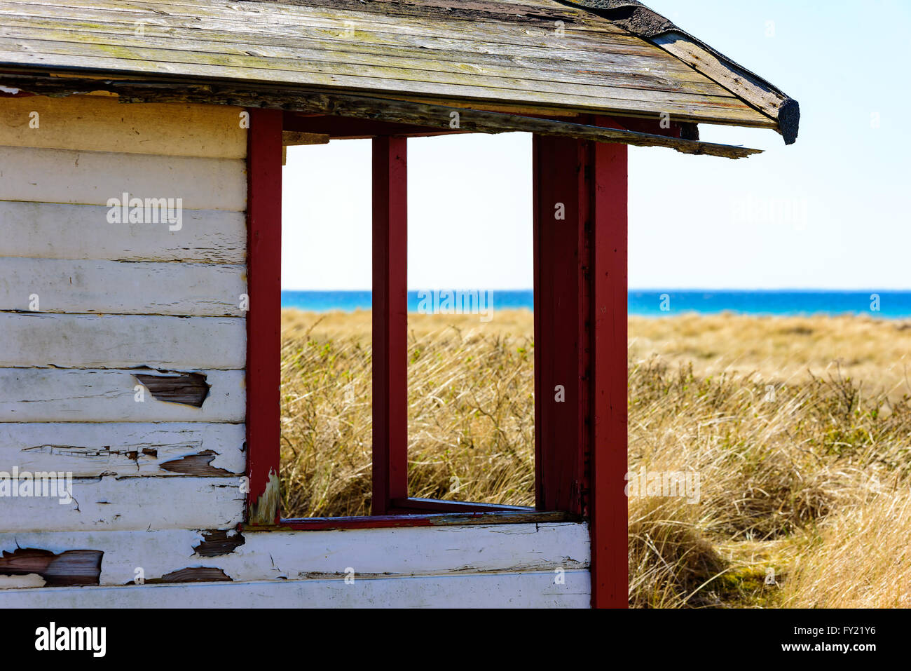 Close up of torn and weathered beach hut opening with the horizon over ...