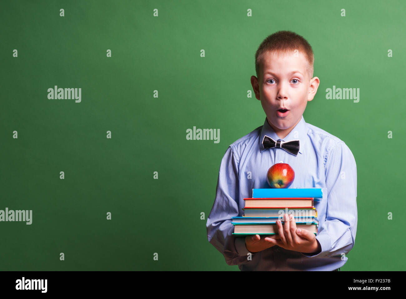 Happy little boy with books isolated on green background Stock Photo ...