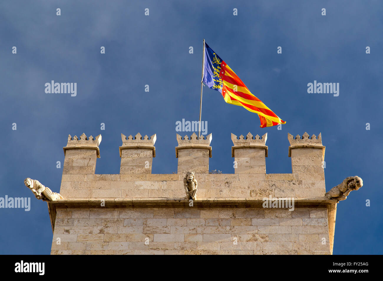 Valencia flag flying over castle tower with crenelations and gargoyles ...