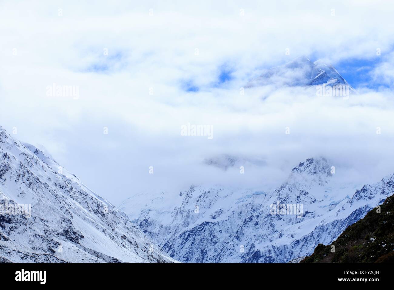 The summit of Mt Cook pokes out from behind the clouds in the Hooker ...