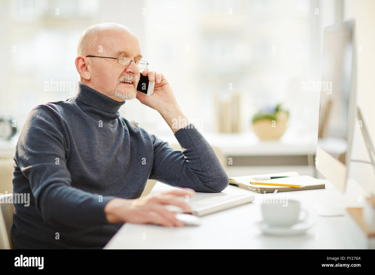 Calling in front of computer Stock Photo - Alamy