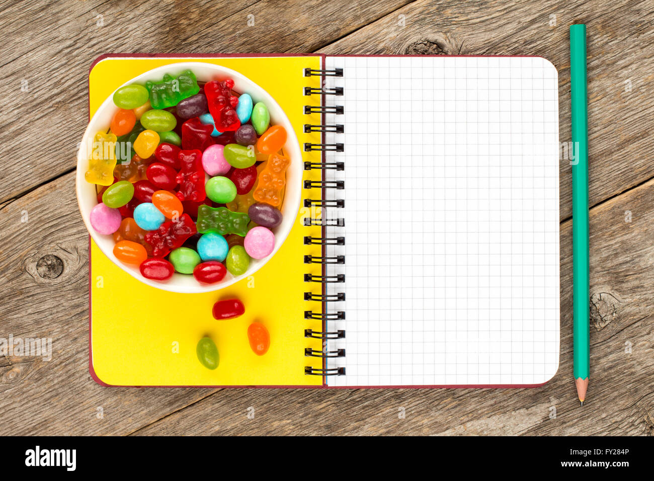 Blank notebook and bowl with mixed candies Stock Photo - Alamy