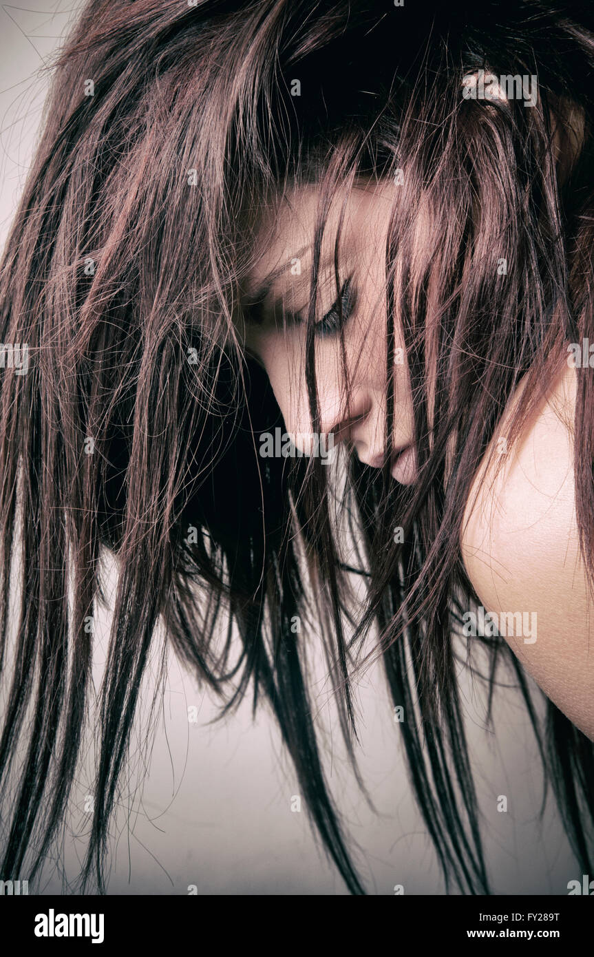 Depressed young woman hair covering face Stock Photo - Alamy