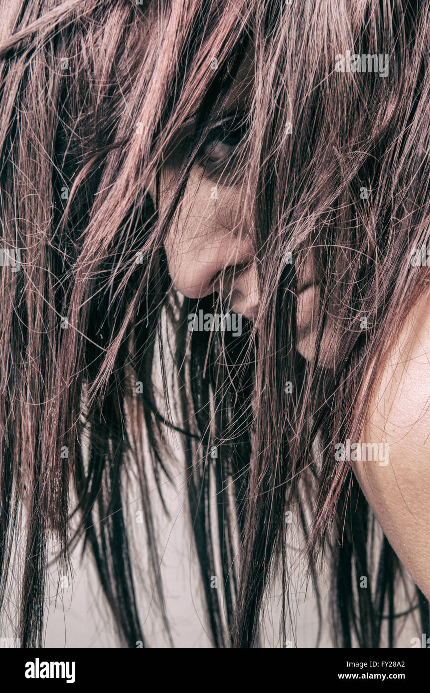 Depressed young woman hair covering face Stock Photo - Alamy