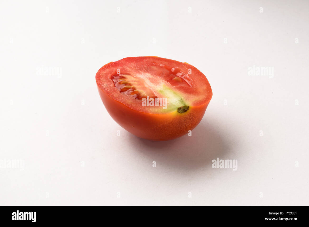 Fresh cut tomato in half single Stock Photo - Alamy