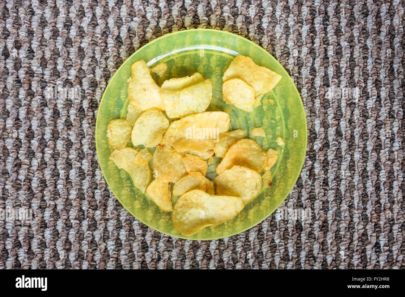 Crisps on a child's yellow plastic plate Stock Photo - Alamy