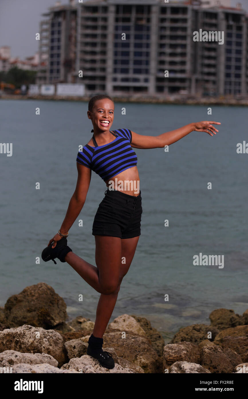 Woman posing on the rocks and smiling Stock Photo - Alamy