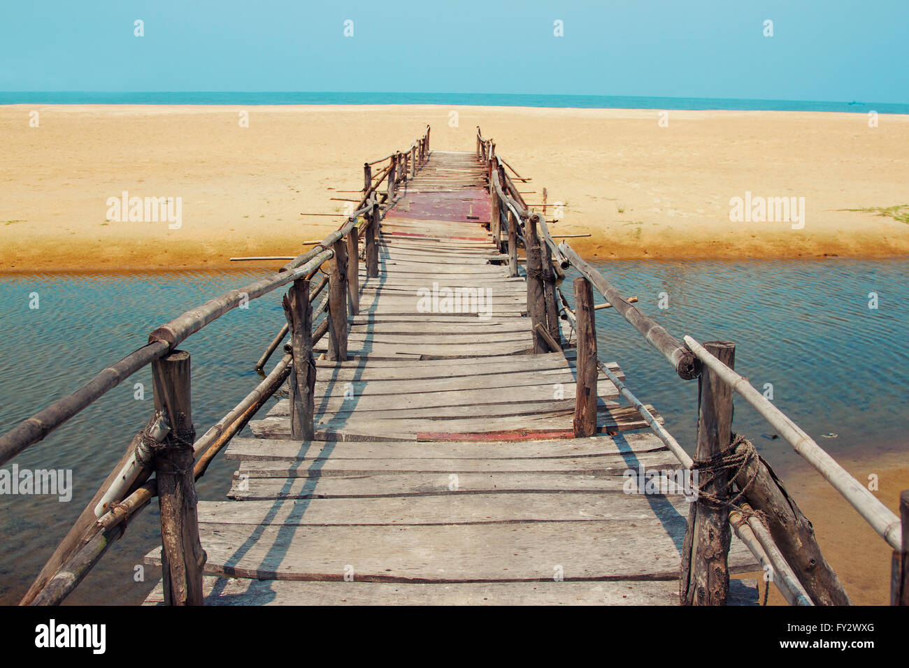 Creative travel photo with blue sky, sea, beach and wood plank road ...
