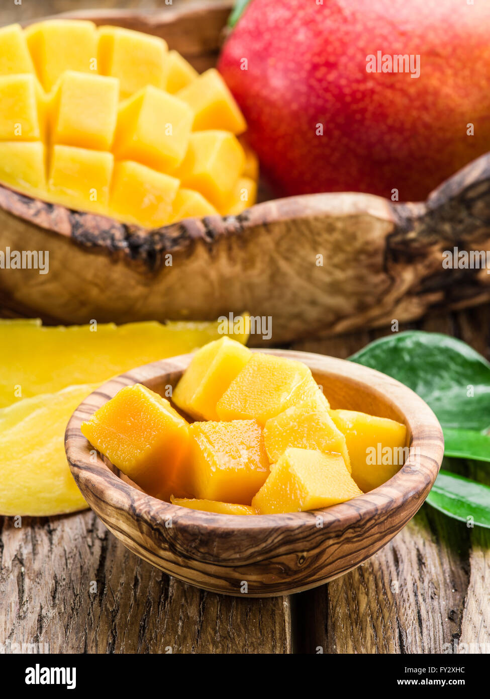 Mango fruit and mango cubes on the wooden table Stock Photo - Alamy