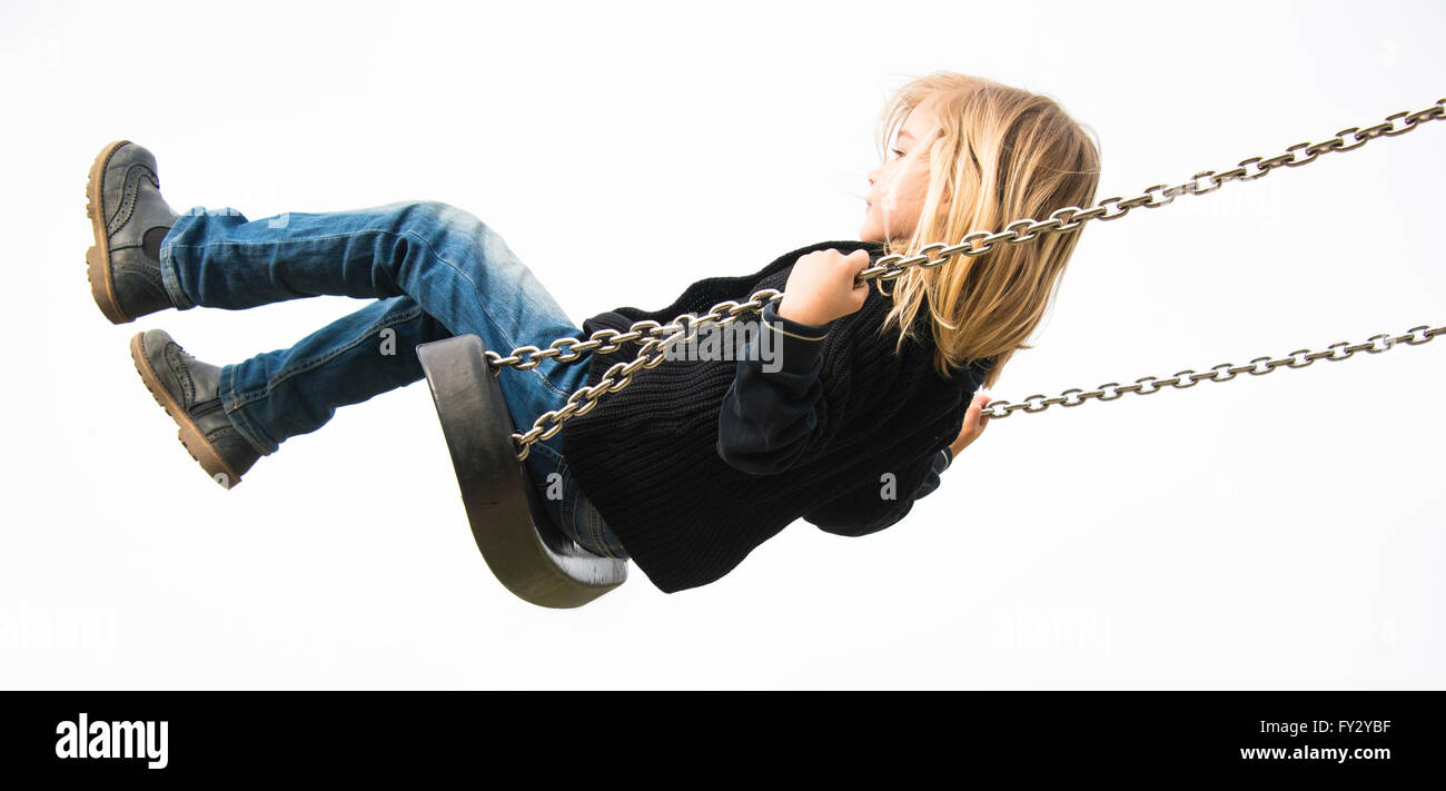Little child blond girl having fun on a swing outdoor. Summer playground. Girl swinging high ...
