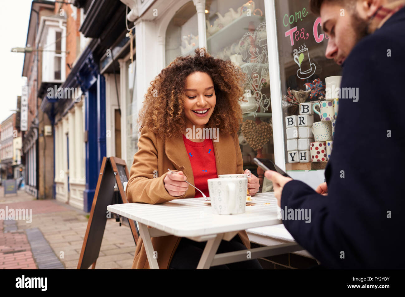 Couple Sitting Outside Cafe Enjoying Coffee And Snack Stock Photo - Alamy