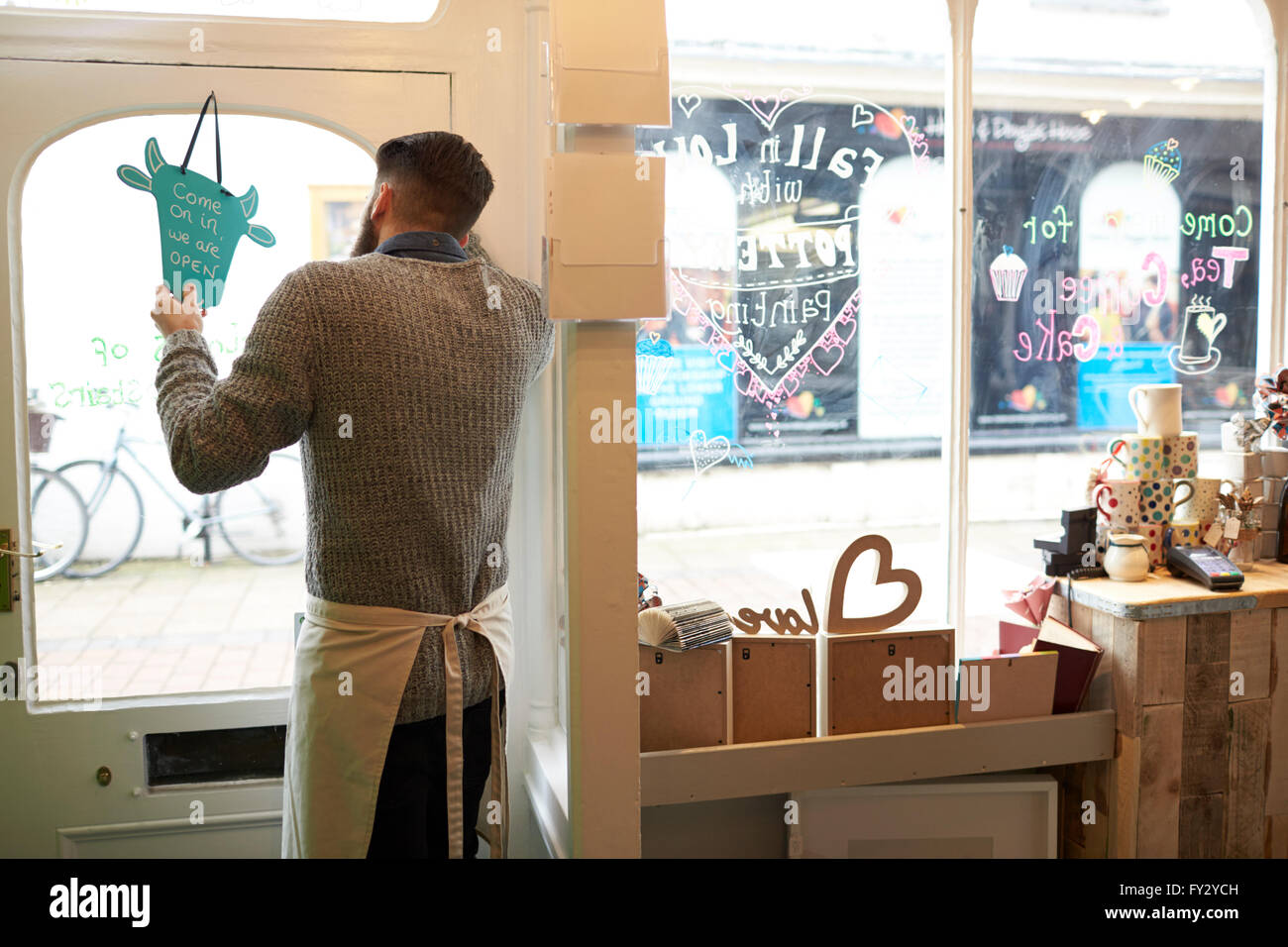 Hipster man turning opening sign hi-res stock photography and images ...