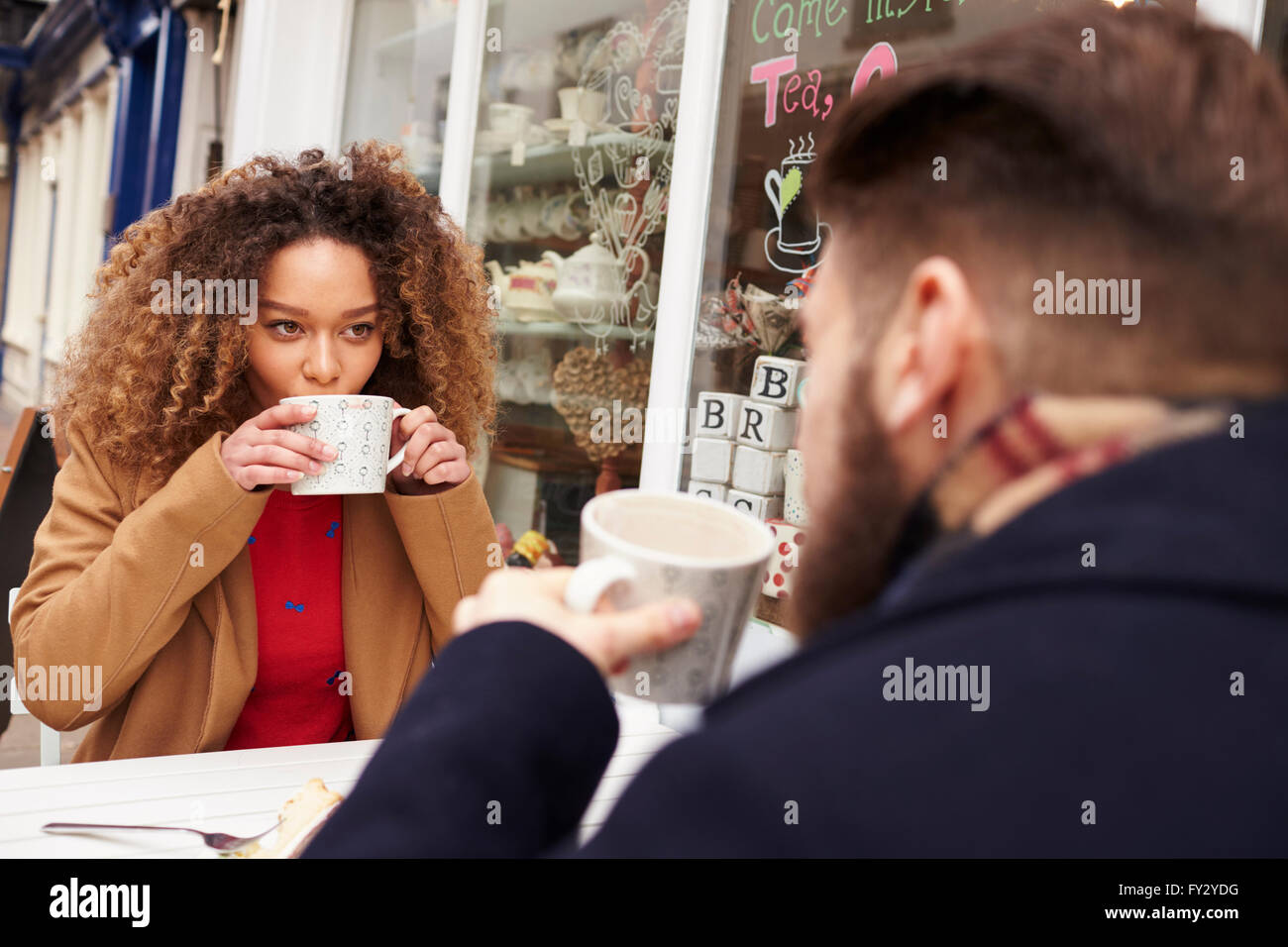 Couple Sitting Outside Cafe Enjoying Coffee And Snack Stock Photo - Alamy