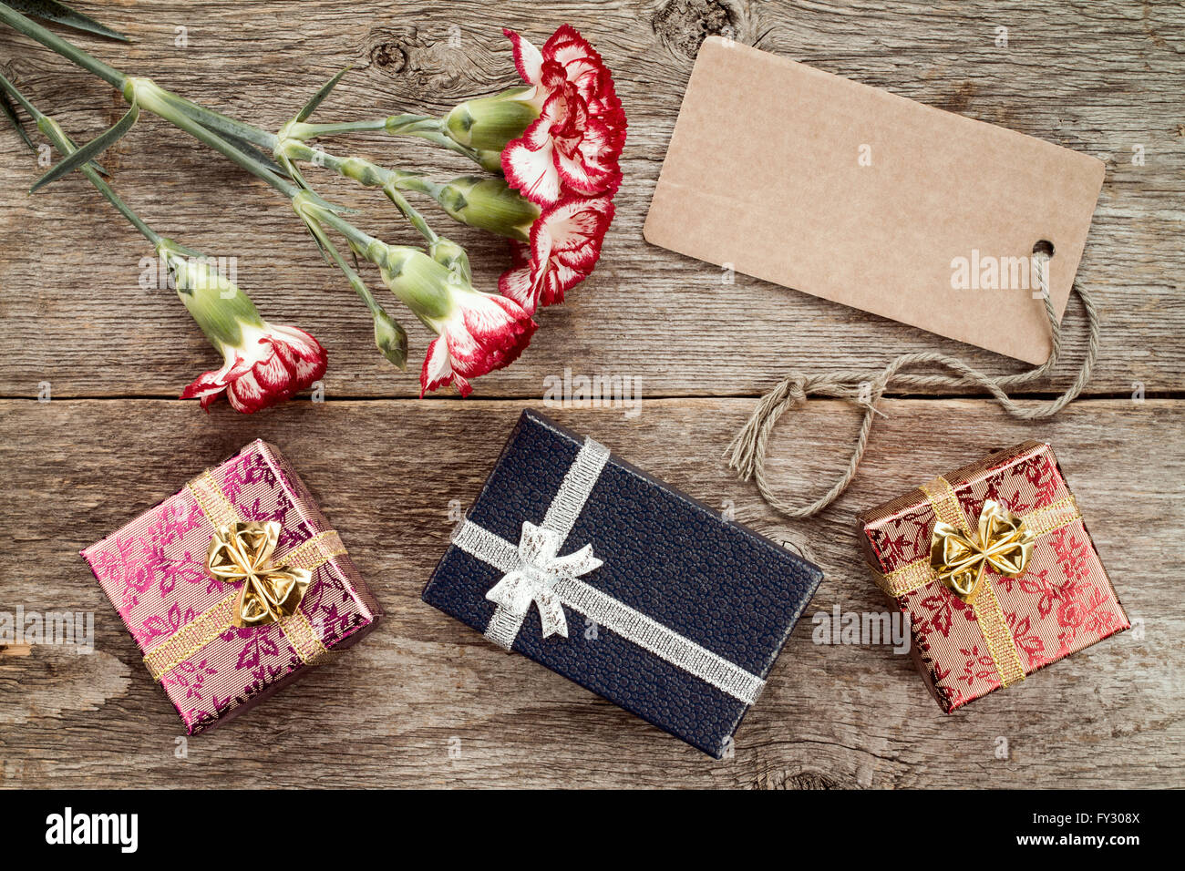 Three gift boxes,carnation and blank tag for your text Stock Photo - Alamy