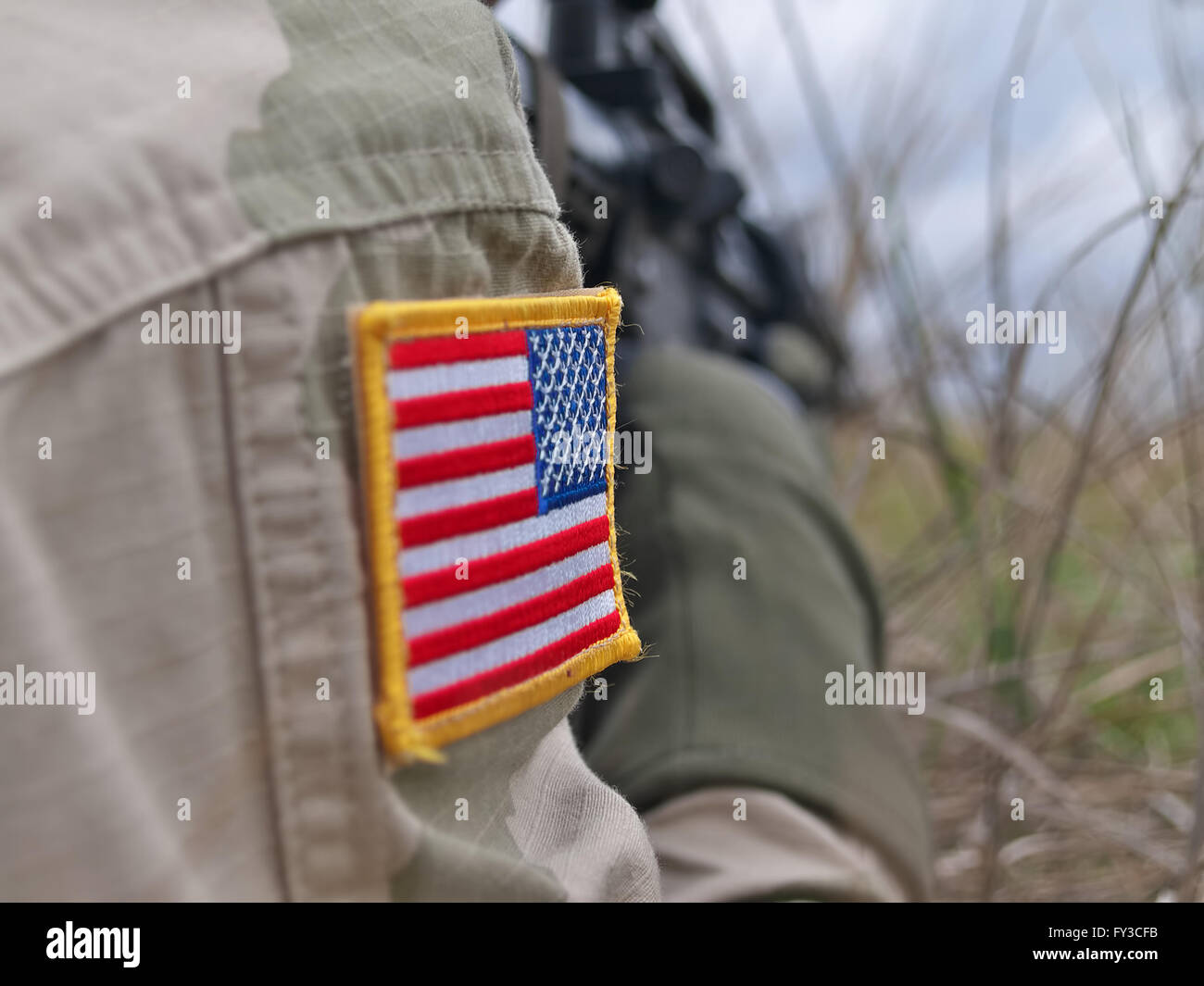 US Army soldier in action - flag patch closeup and rifle on the ...